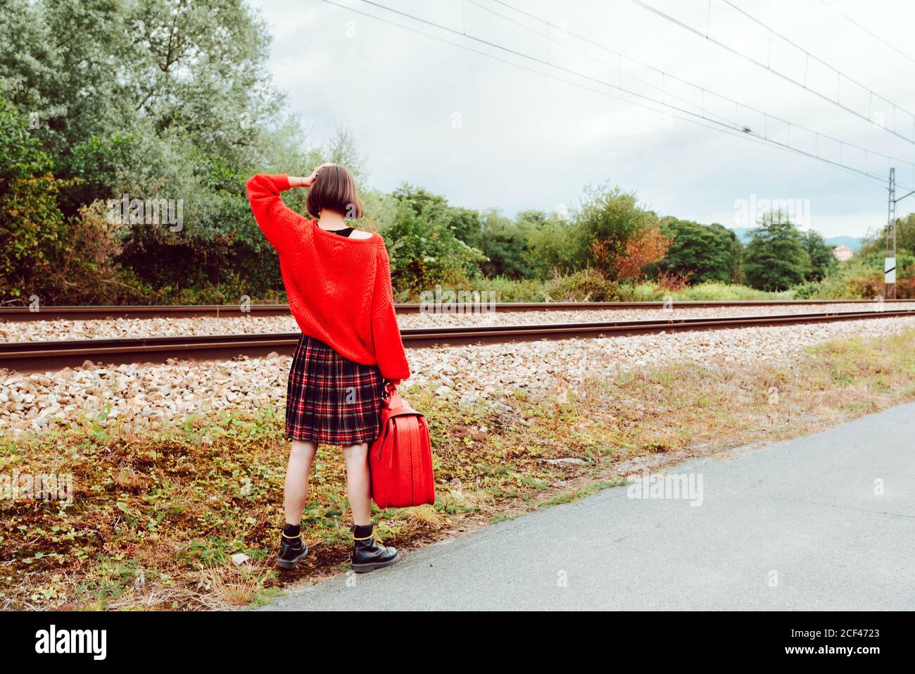 Woman looking at approaching modern train on railroad Stock Photo - Alamy