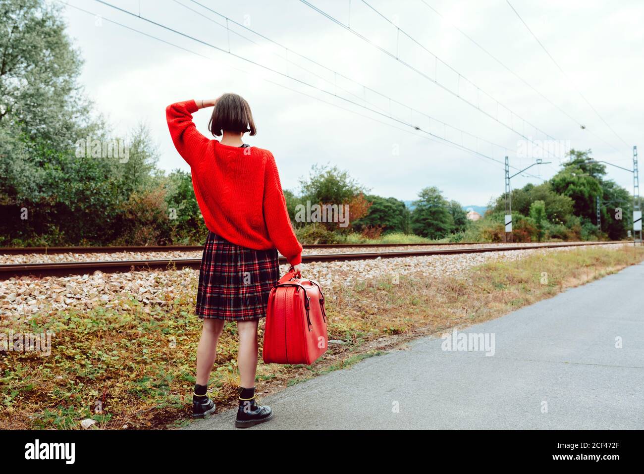 Woman looking at approaching modern train on railroad Stock Photo - Alamy