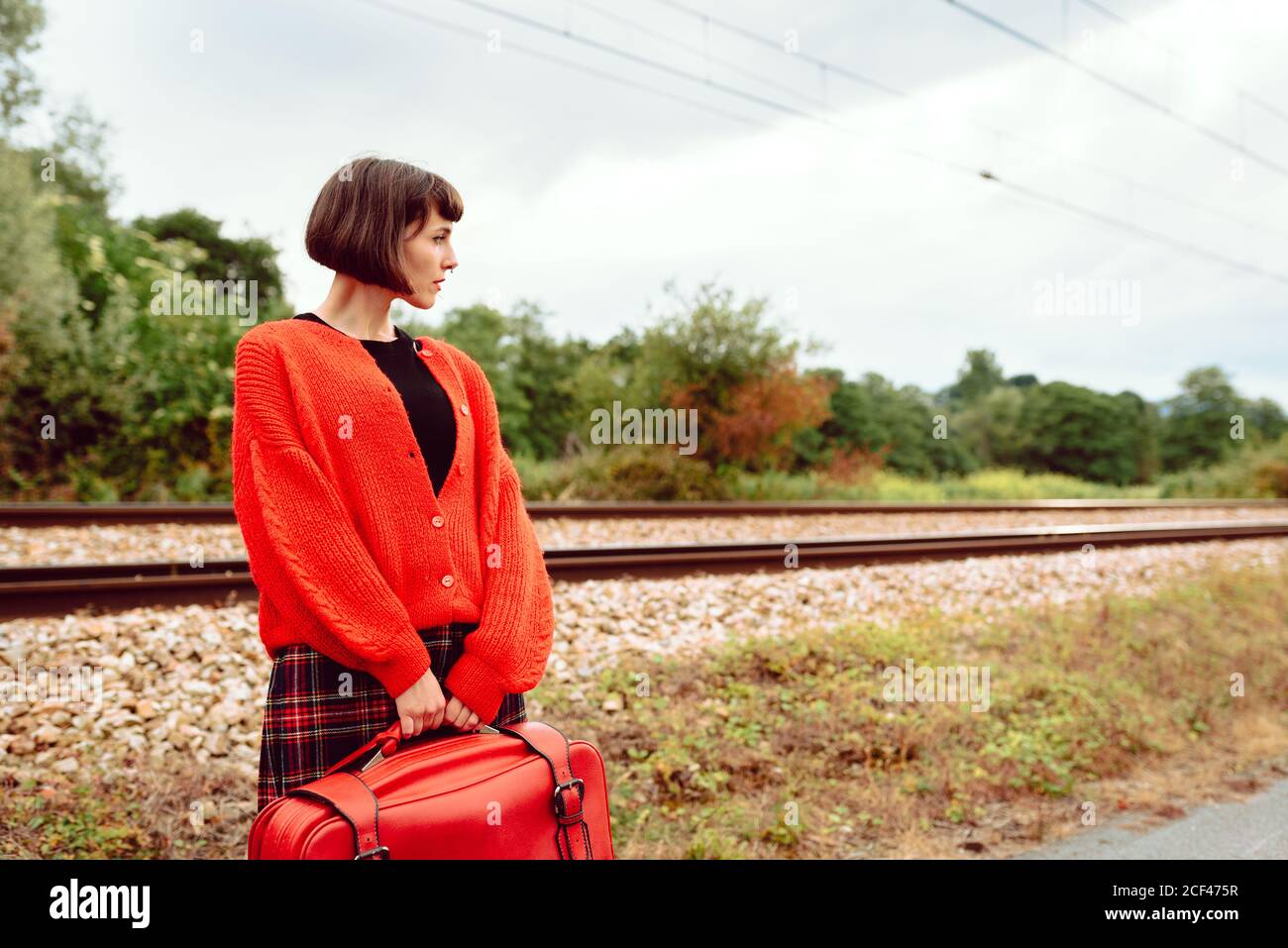 Woman looking at approaching modern train on railroad Stock Photo - Alamy