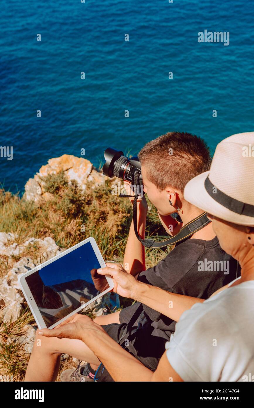 Side view of touristic women exploring sightings at rocky coast with ...