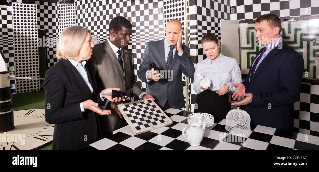 Focused pensive business partners discussing in escape room stylized ...