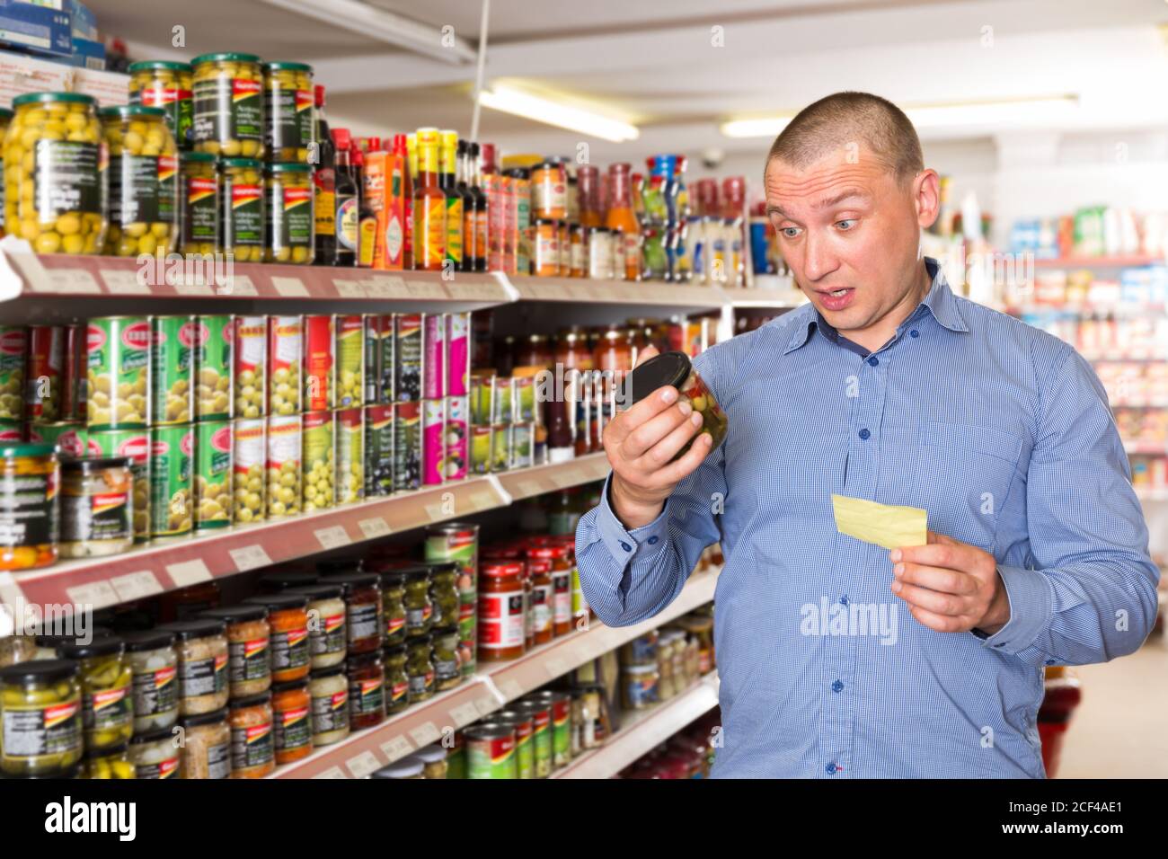 Portrait of male purchasing food products on shopping list in ...
