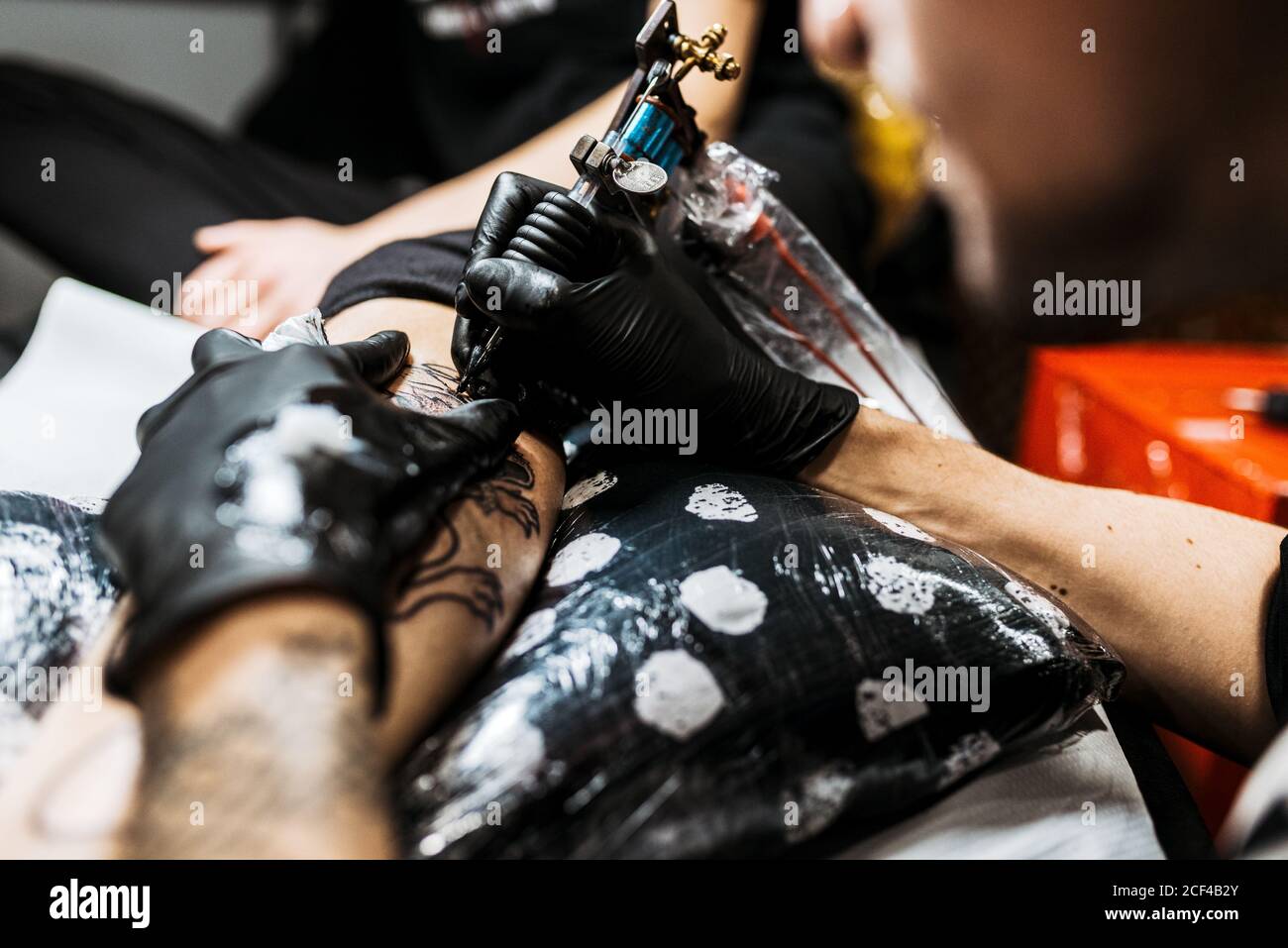 From above cropped unrecognizable man with using tattoo machine to make ...