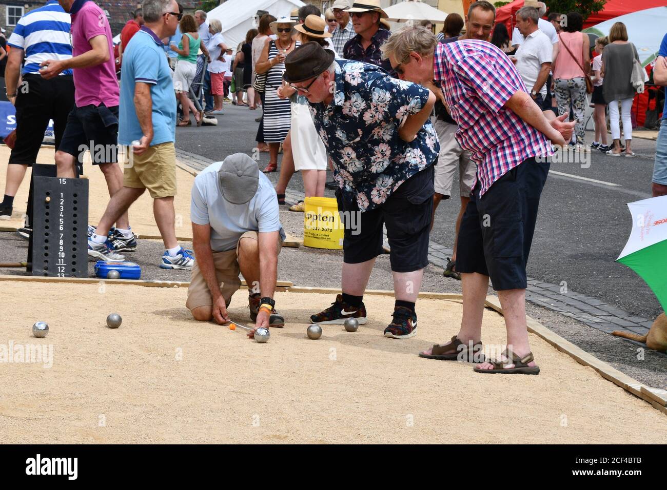 Keen players measuring the outcome at the International Boules ...