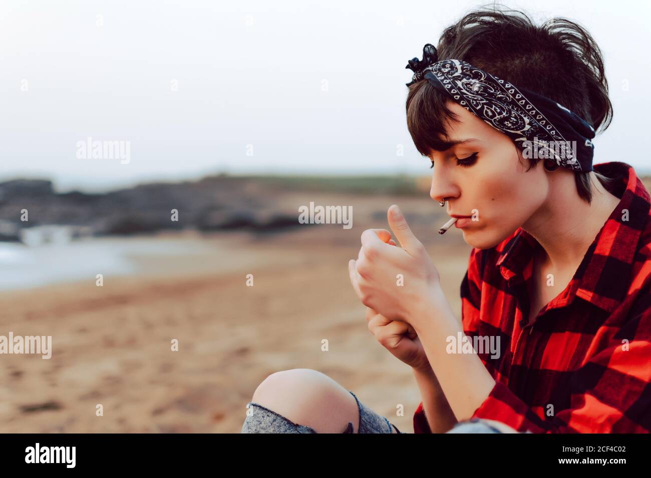 Woman lighting cigarette hi-res stock photography and images - Alamy