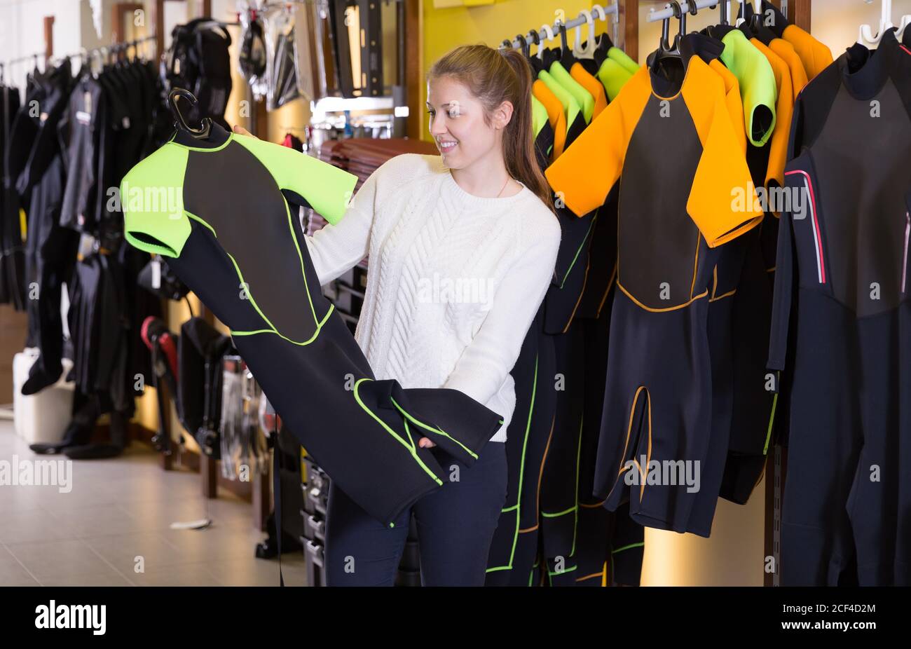 Female is standing with modern diving costumes in the store Stock Photo ...