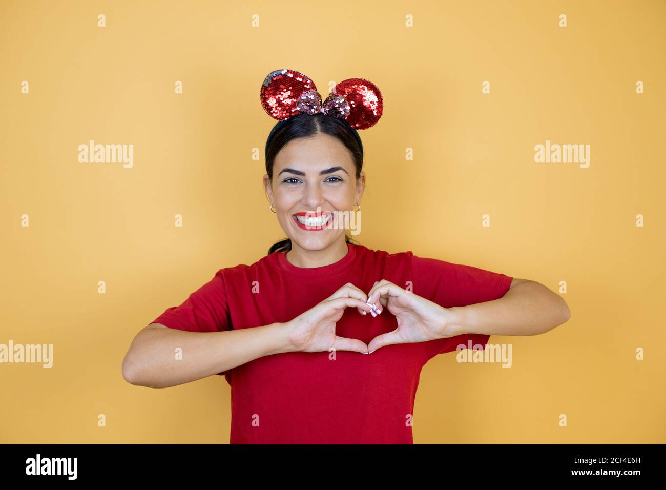 Young beautiful woman wearing mouse ears over isolated yellow ...