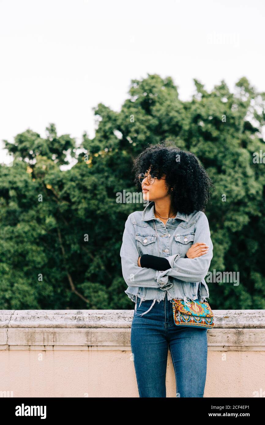 Young trendy African American Woman in jeans and crop top sitting on ...