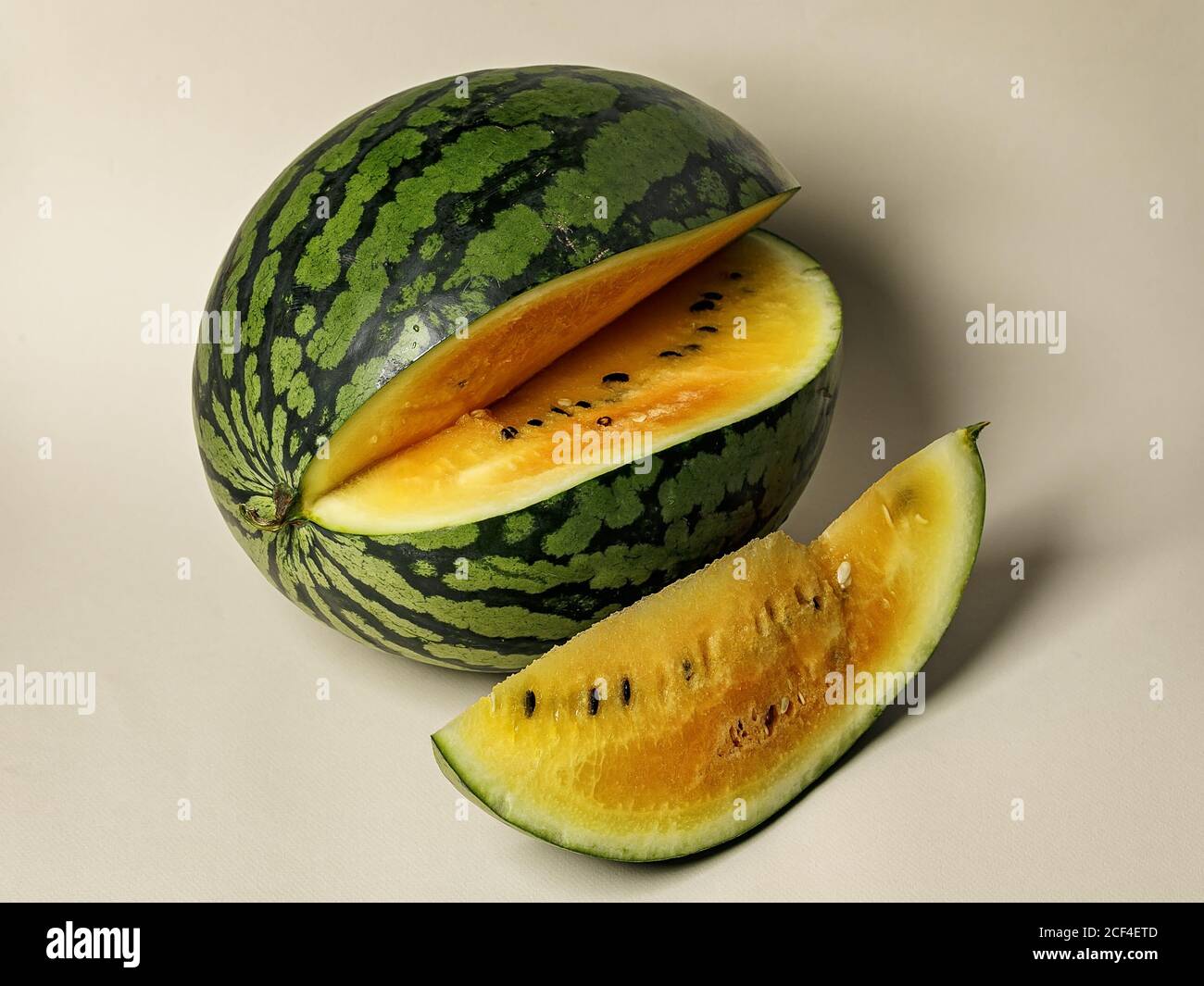 Ripe sweet yellow watermelon on a beige background. Organic and farm ...