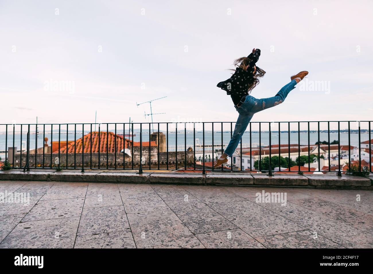 Side view of casual teen Woman flying in splits while dancing ...