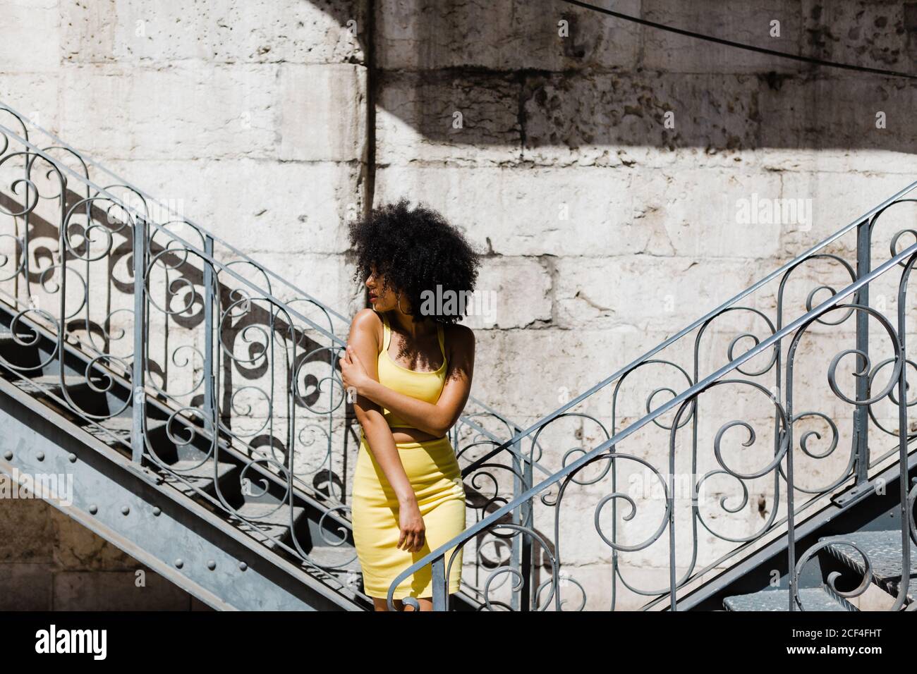 Beautiful African American Woman in yellow suit standing and leaning in ...