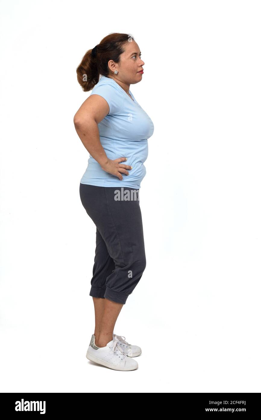 side view of a woman with sportswear on white background, hands on hip ...