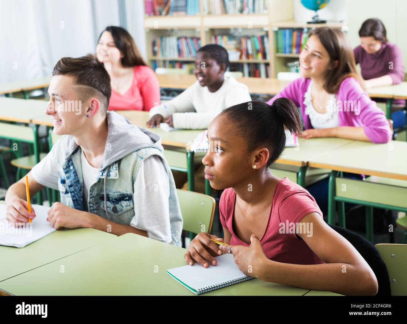 Portrait of positive school students taking a lesson in the school ...