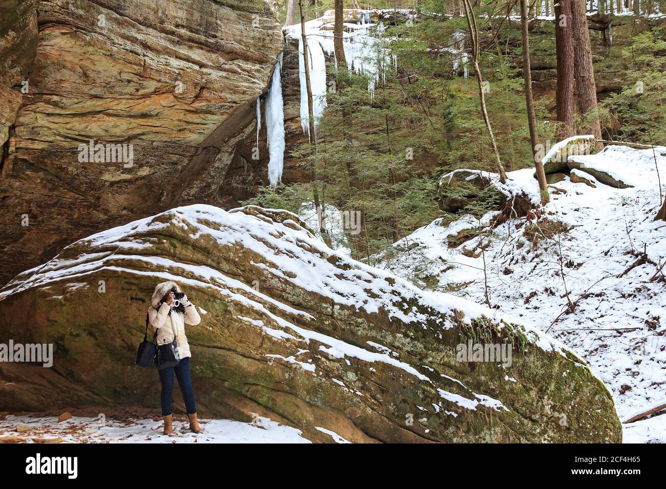 Woman photographs ice formations at Ash Cave, one of several caves with ...