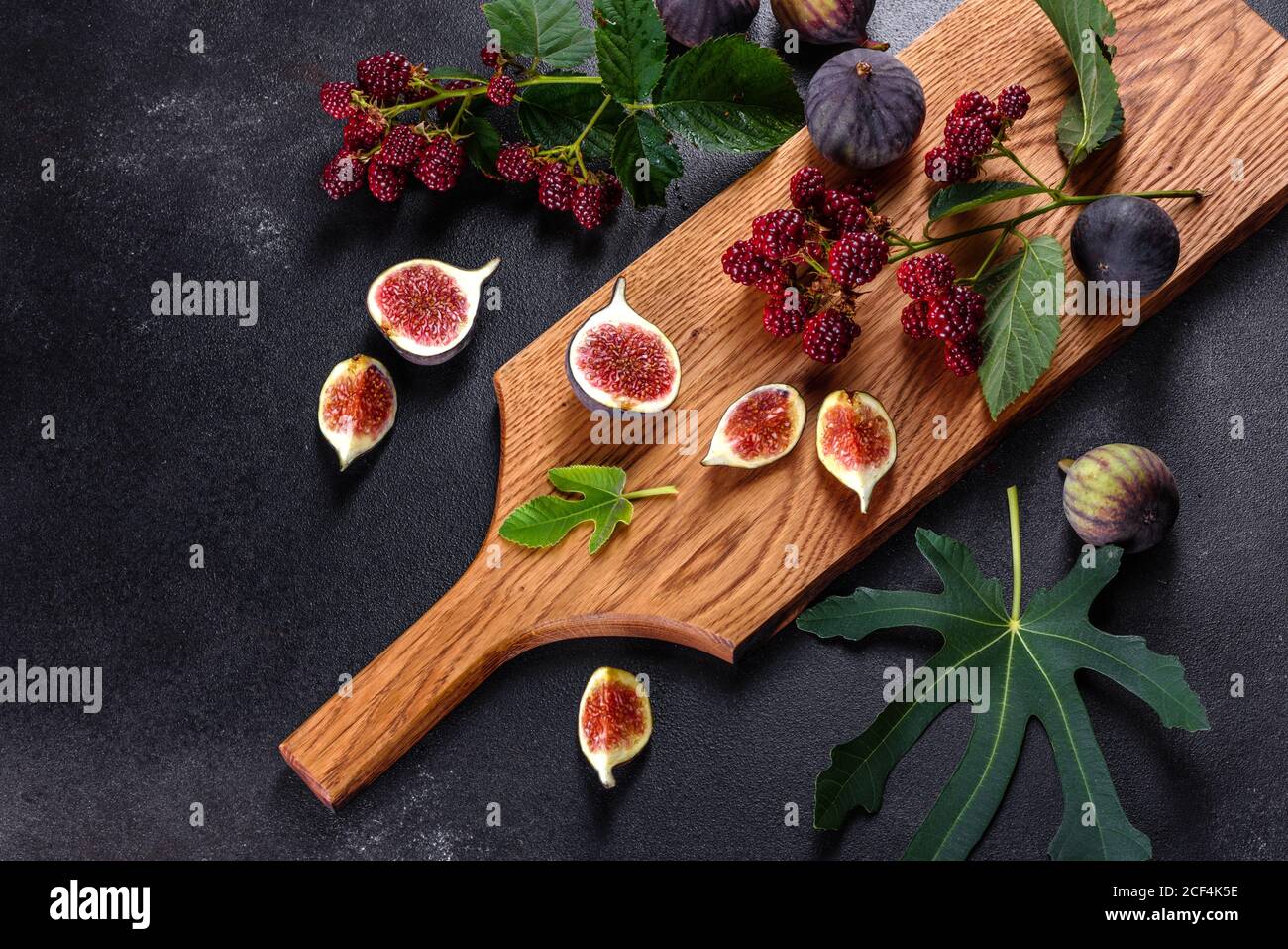 Fresh juicy figs and blackberries on a dark background. Harvesting ...