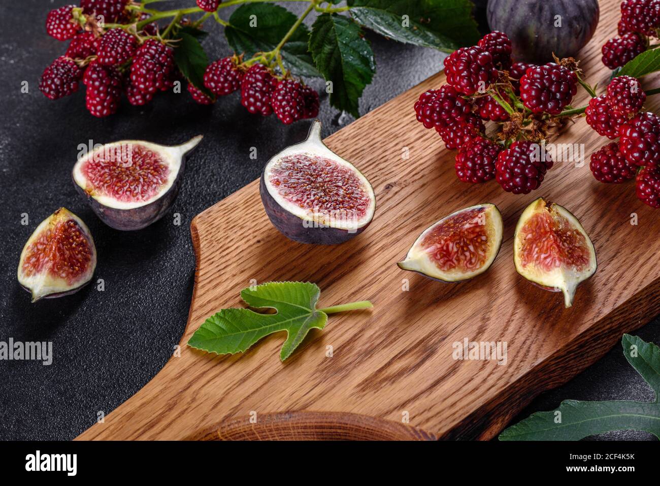 Fresh juicy figs and blackberries on a dark background. Harvesting ...