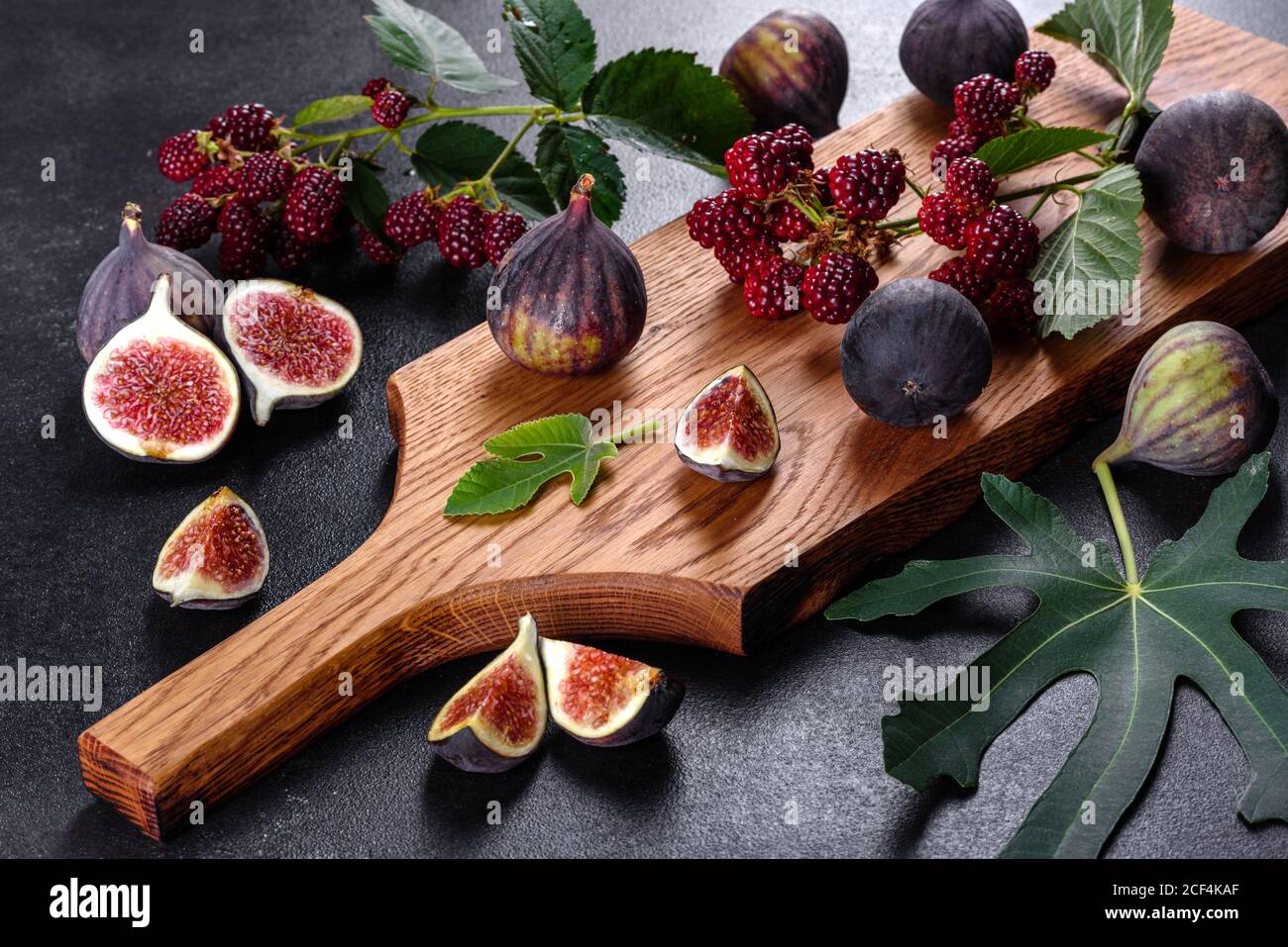 Fresh juicy figs and blackberries on a dark background. Harvesting ...