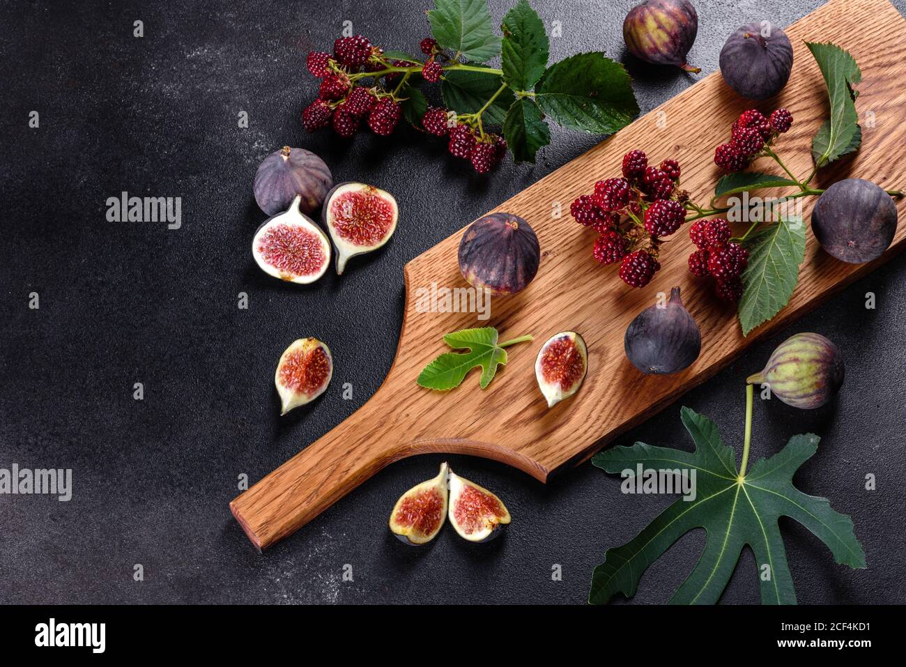 Fresh juicy figs and blackberries on a dark background. Harvesting ...