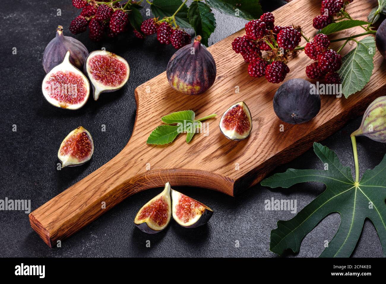 Fresh juicy figs and blackberries on a dark background. Harvesting ...