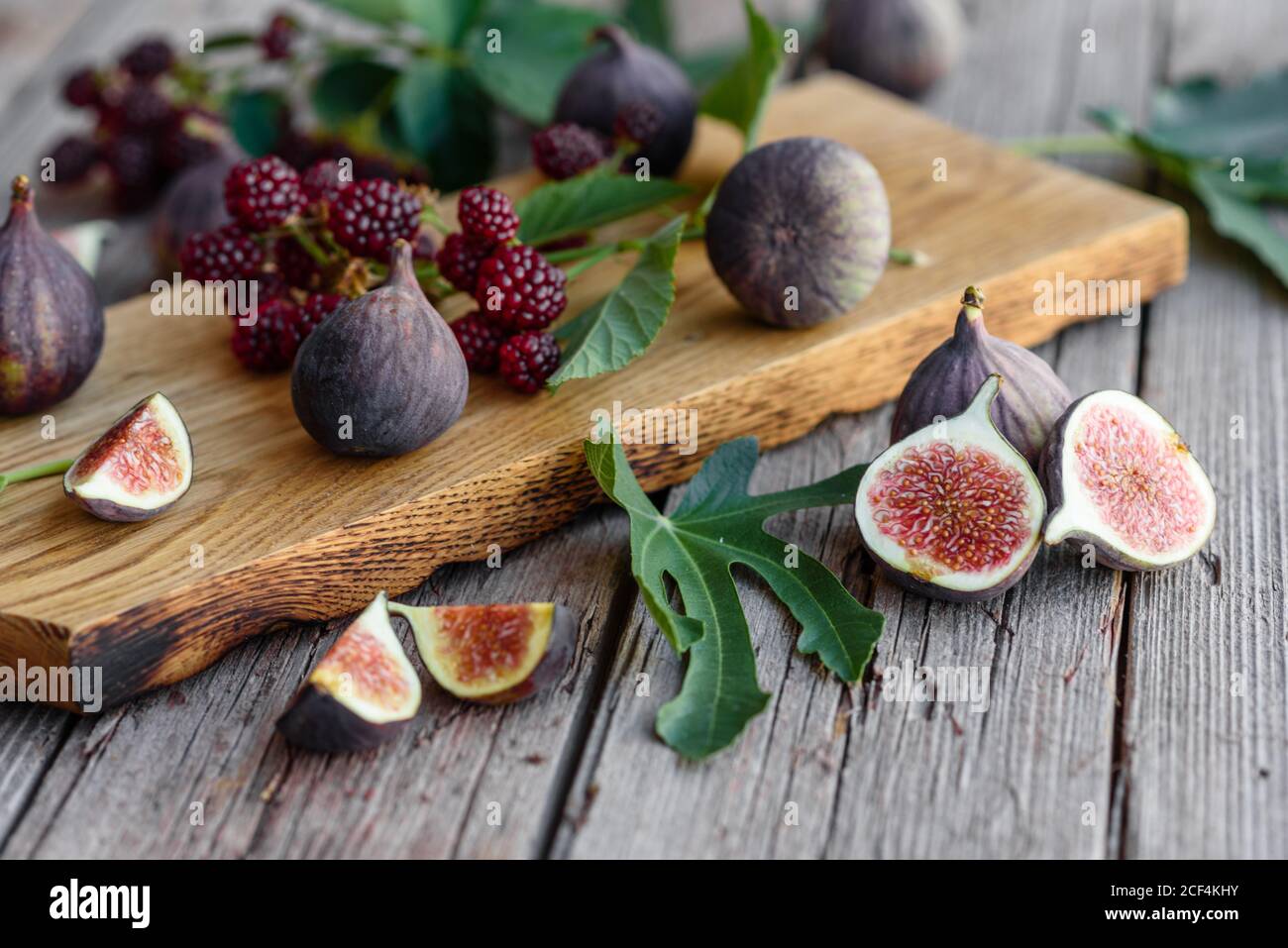 Fresh juicy figs and blackberries on a dark background. Harvesting ...