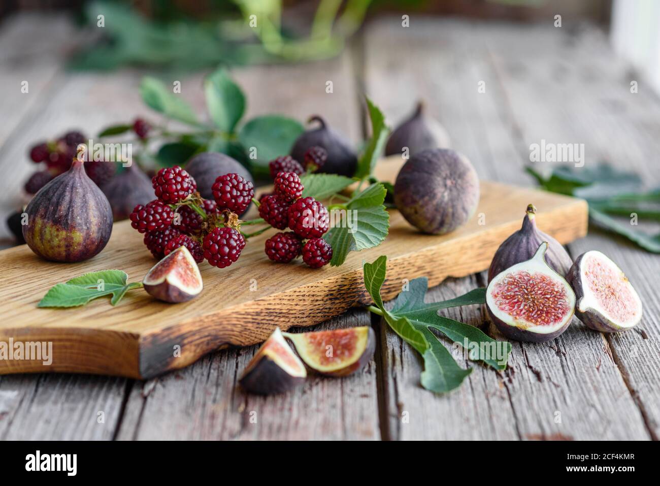 Fresh juicy figs and blackberries on a dark background. Harvesting ...
