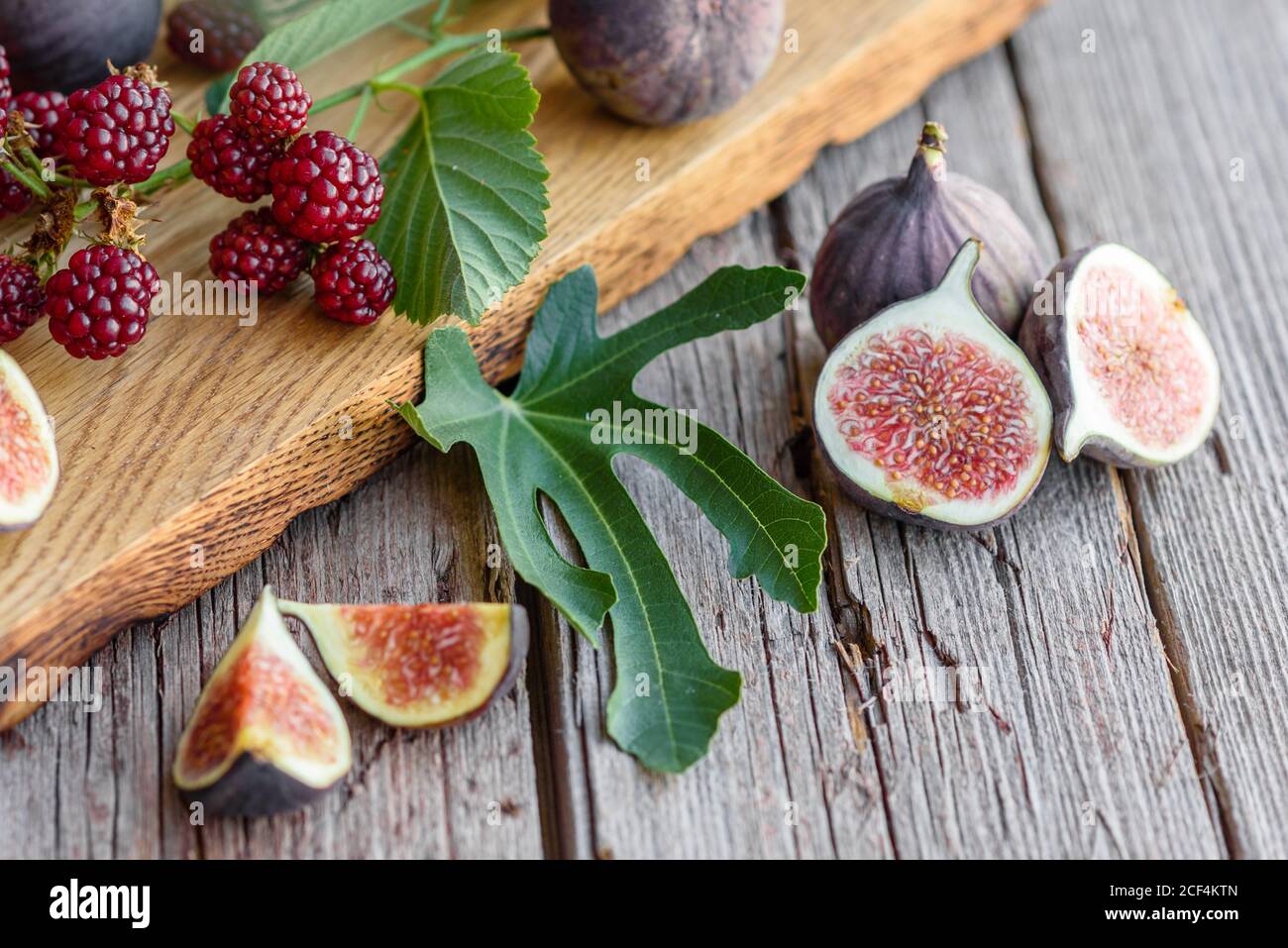 Fresh juicy figs and blackberries on a dark background. Harvesting ...