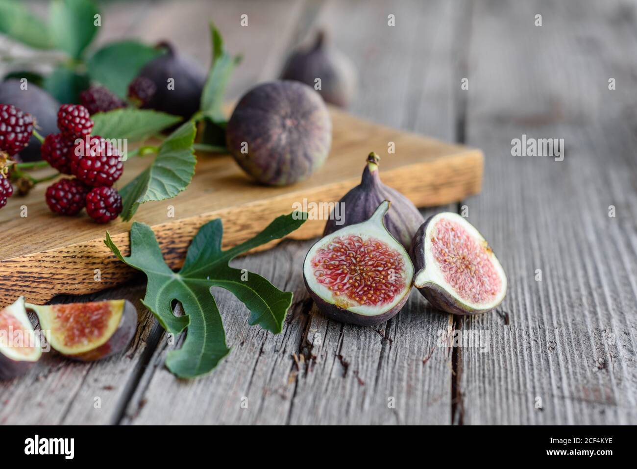 Fresh juicy figs and blackberries on a dark background. Harvesting ...