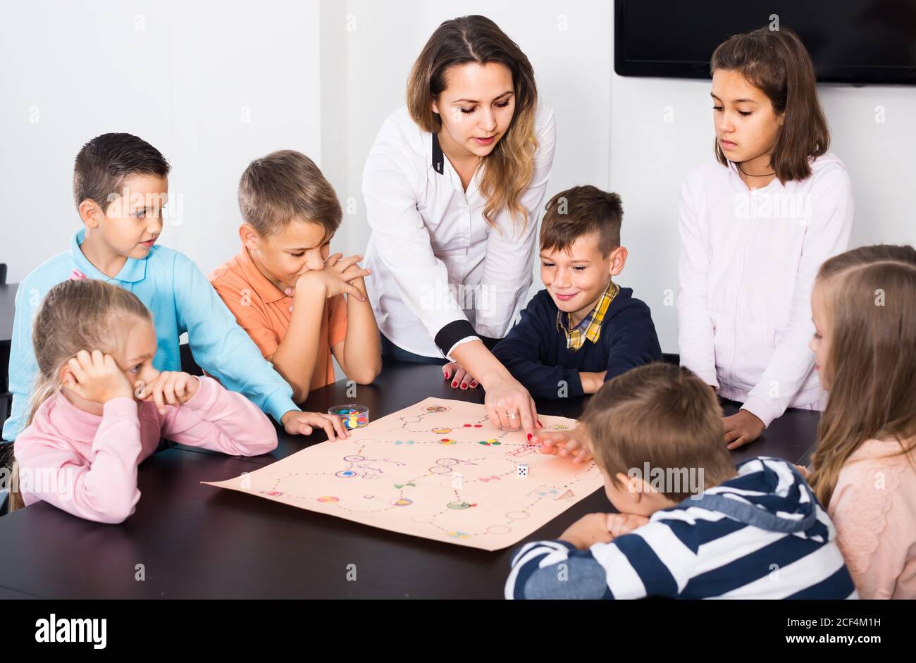 positive russian children making move on pre-marked surface of board ...