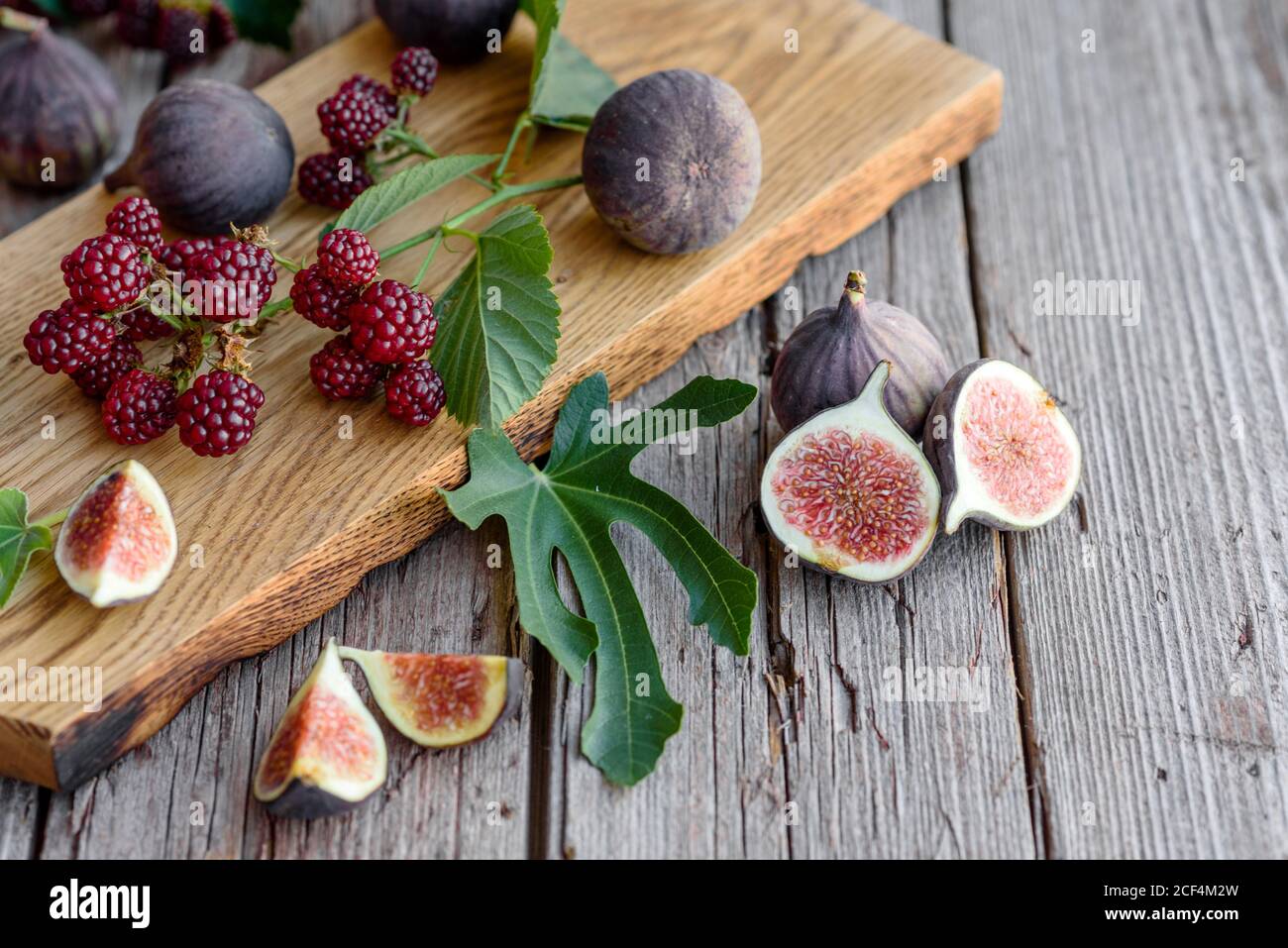 Fresh juicy figs and blackberries on a dark background. Harvesting ...