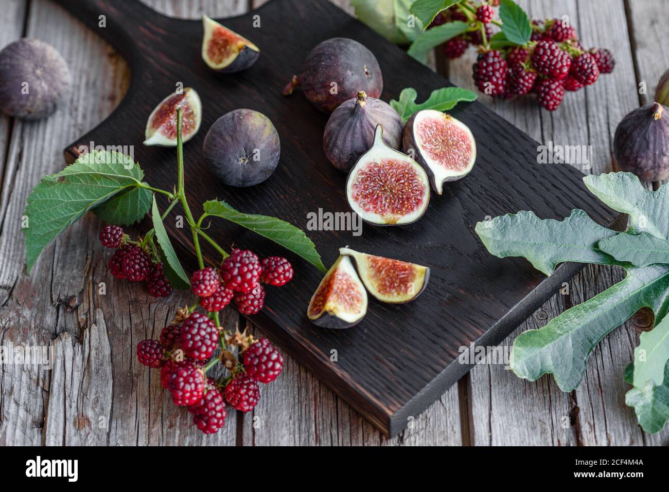 Fresh juicy figs and blackberries on a dark background. Harvesting ...
