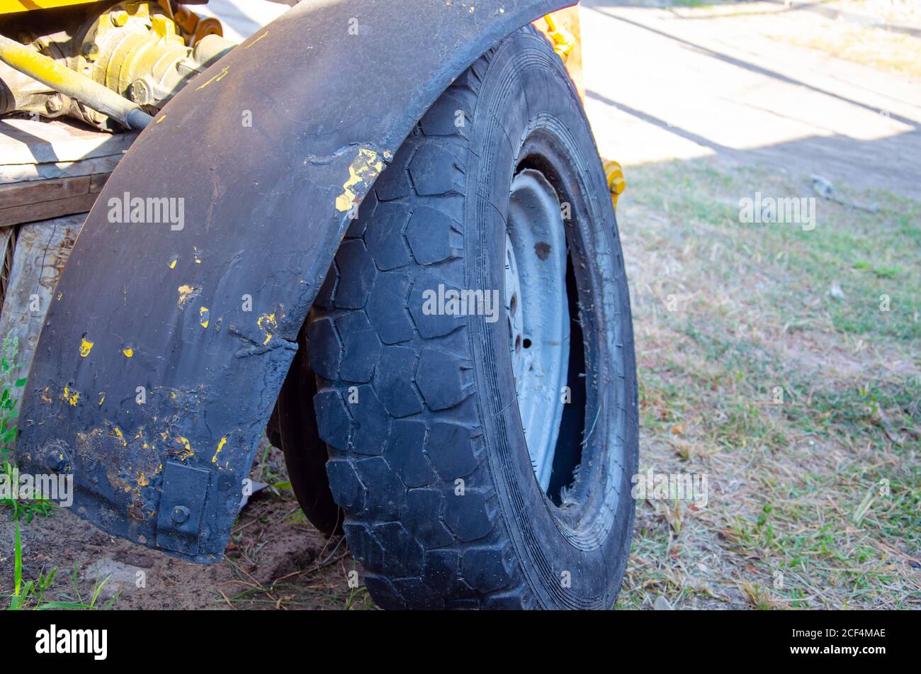 Old rusty tractor's flat back tire. industrial Stock Photo - Alamy