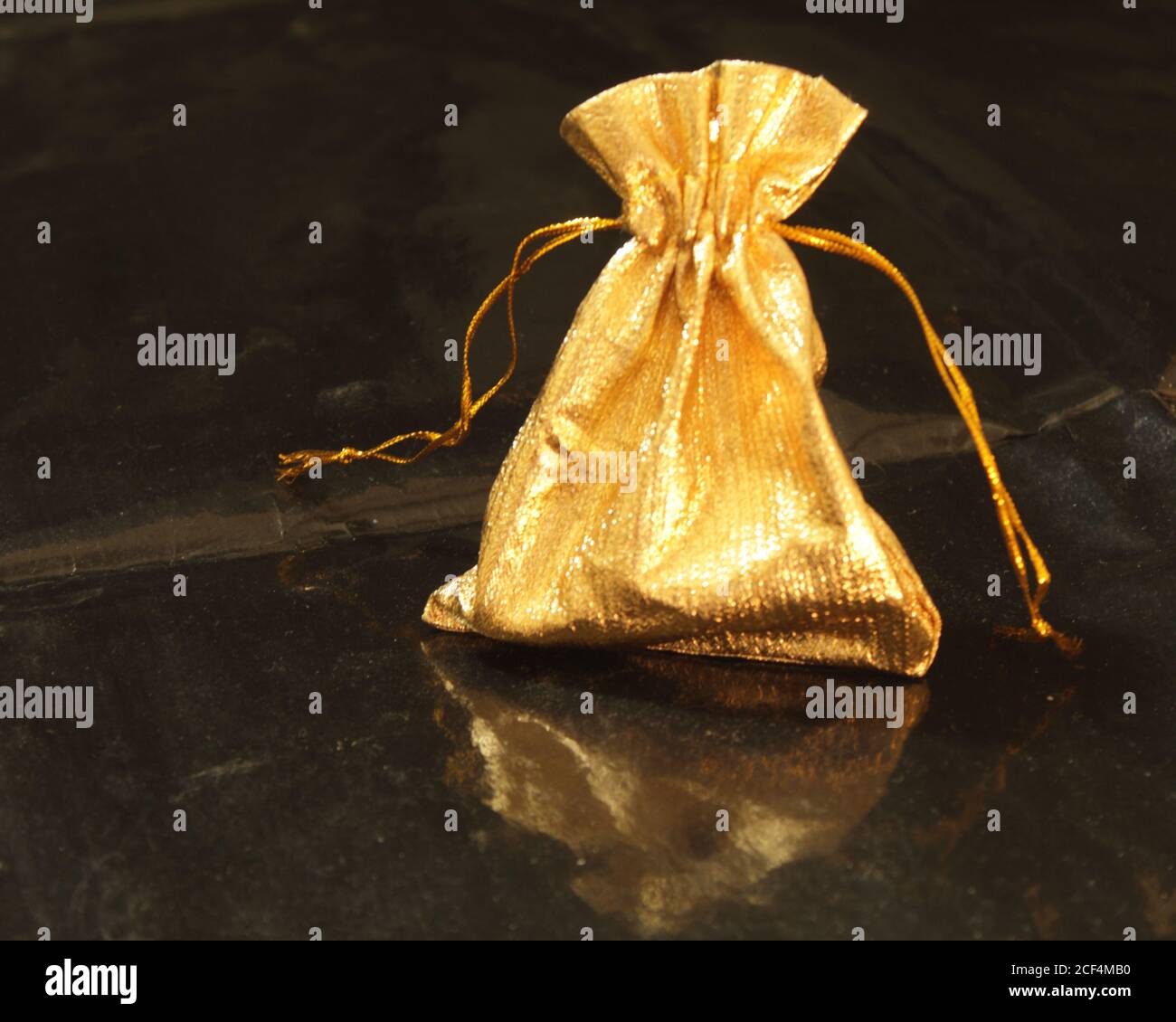 Golden treasure bag on a black background Stock Photo - Alamy