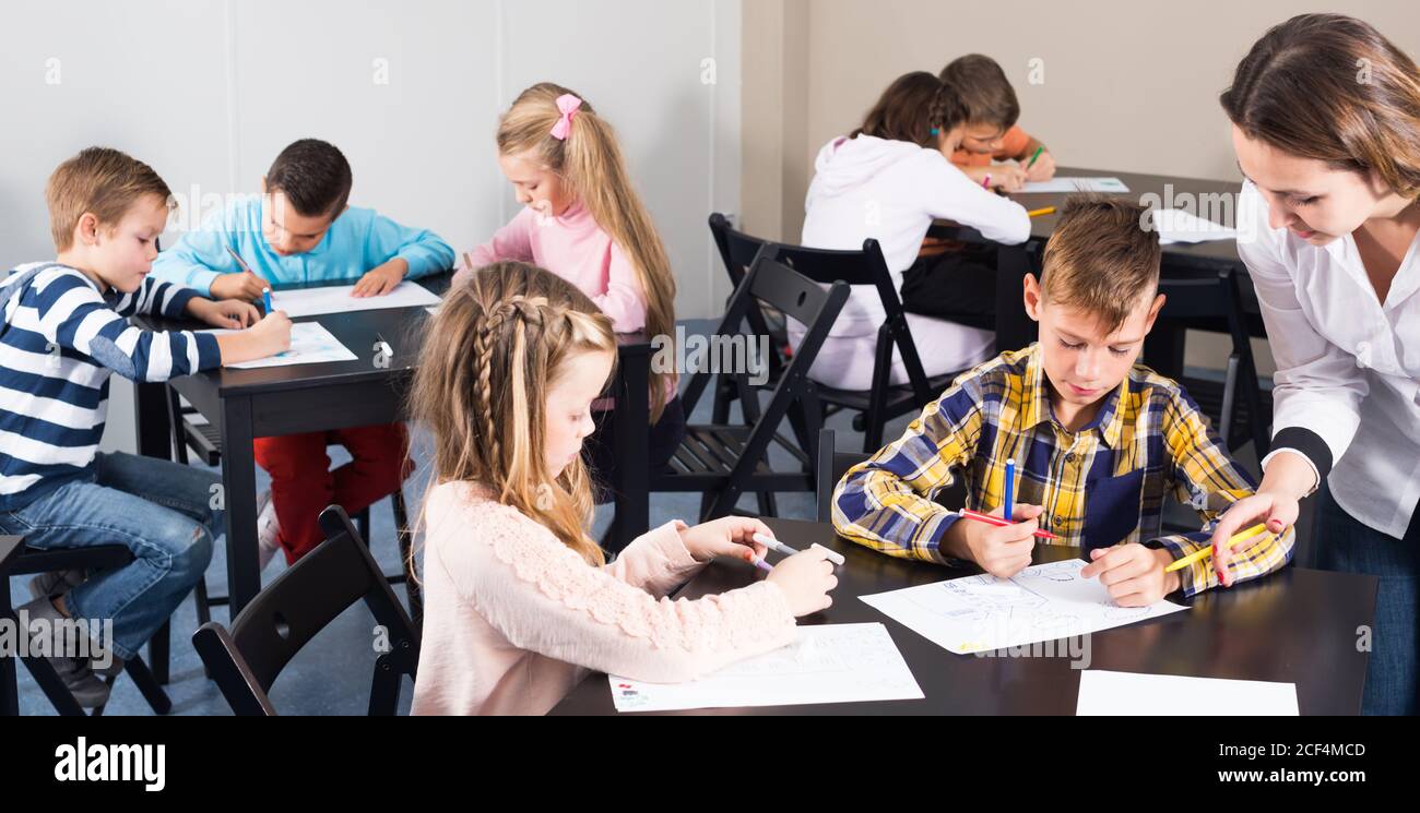 Little happy children with teacher drawing in classroom on the lesson ...