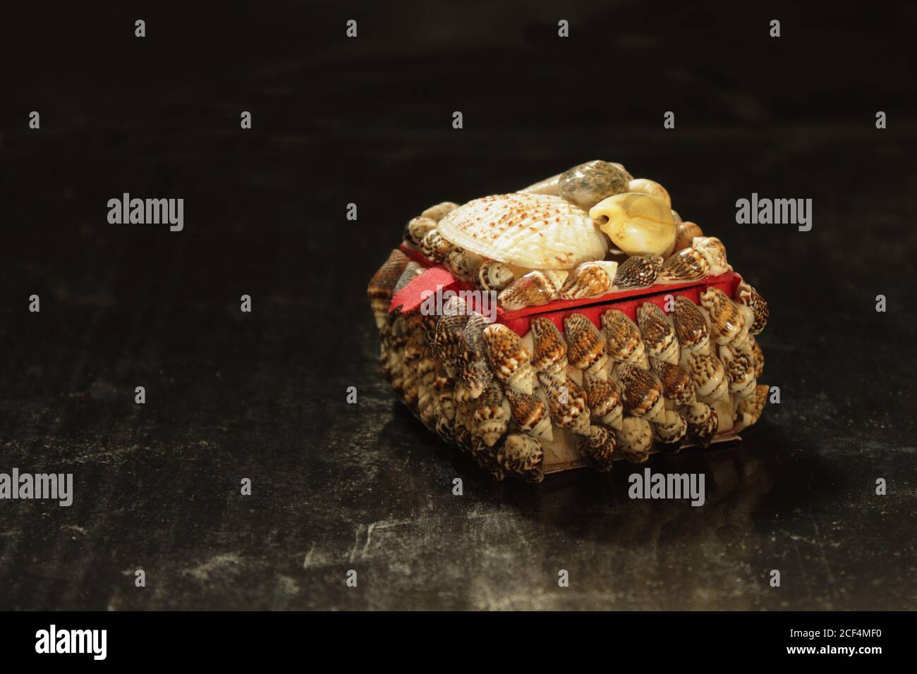 Small box covered with shells on a black background Stock Photo - Alamy