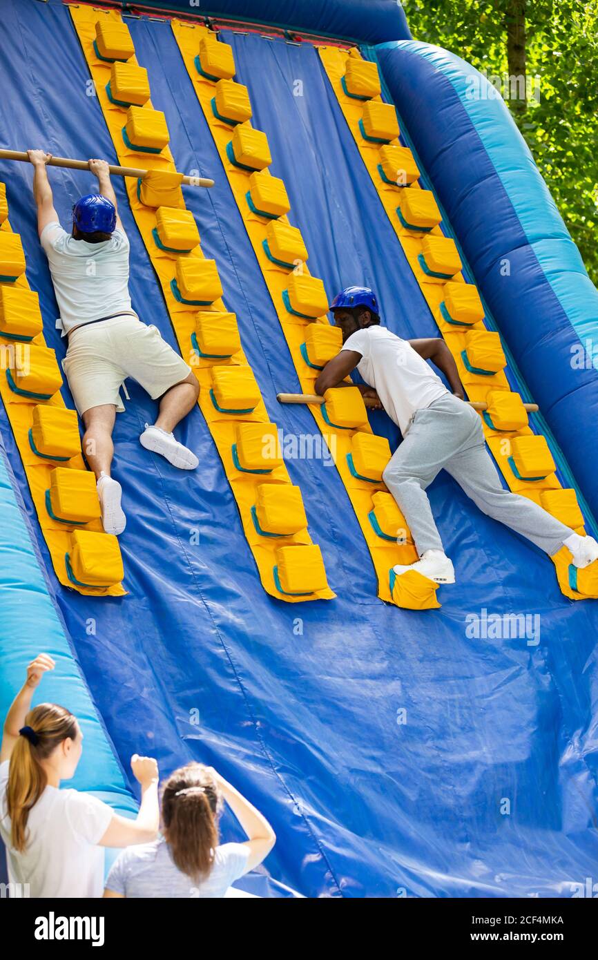 Mens competition on an inflatable slide Great race in an amusement park ...