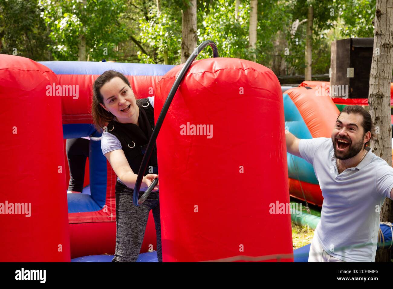 Portrait of emotional young woman putting hoop on inflatable pole ...
