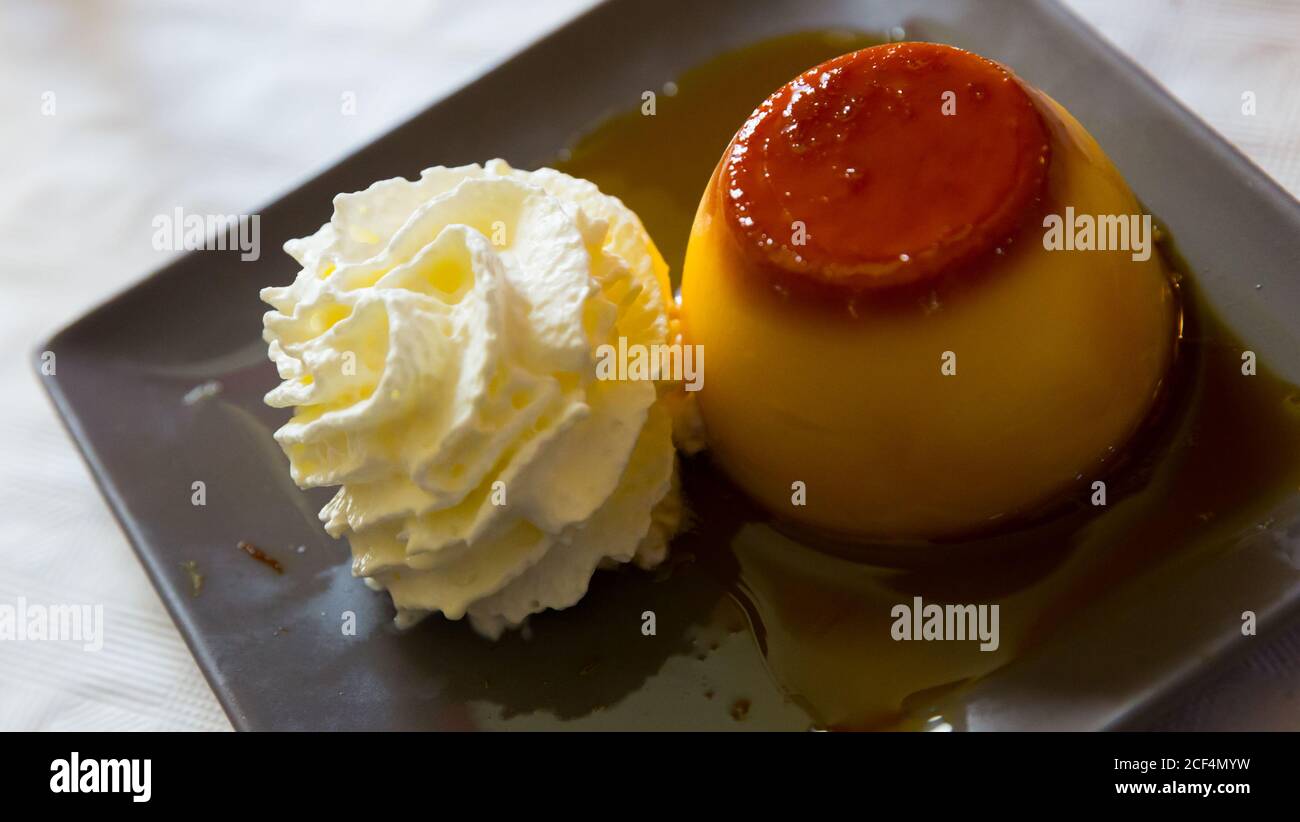 Delicate vanilla caramel flan served with whipped cream. Traditional ...