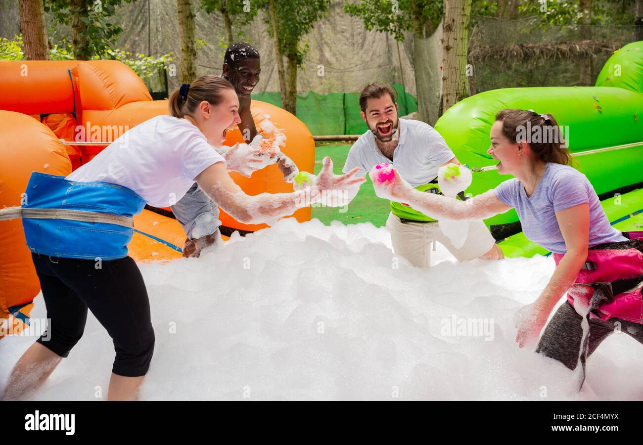 Game of funny friends in soap suds on an inflatable trampoline Stock ...