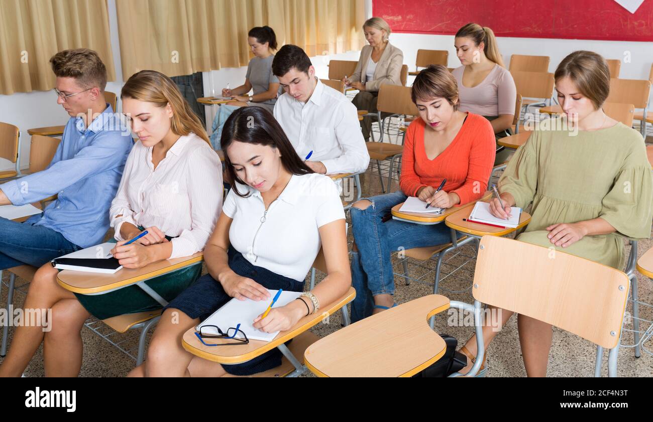 Small group of students attentively listening to lecture in classroom ...