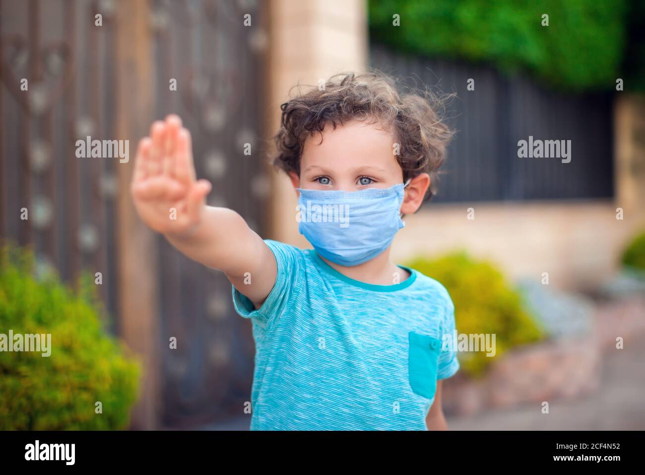 Kid boy with medical face mask showing stop gesture outdoor ...