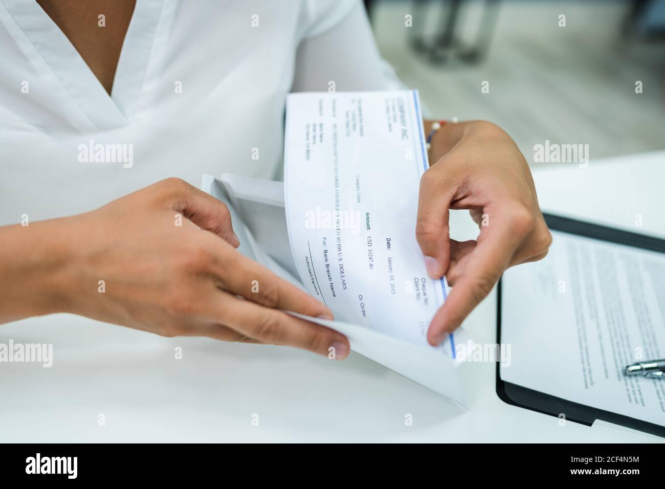 Paycheck In Open Envelope. Holding Payroll Cheque Stock Photo - Alamy