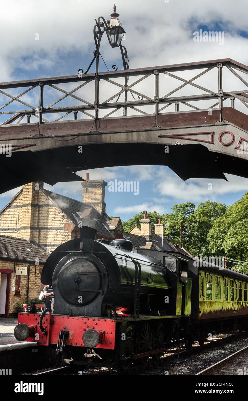 Steam Train Repulse, on railroad track, waits underneath a bridge at ...