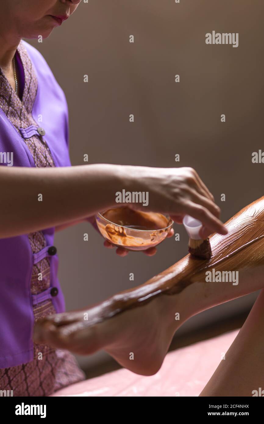 masseur doing Chocolate Mask for foot and legs Stock Photo - Alamy