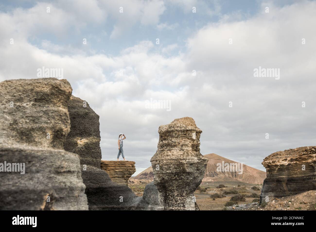 anonymous female standing of stony terrain Stock Photo - Alamy