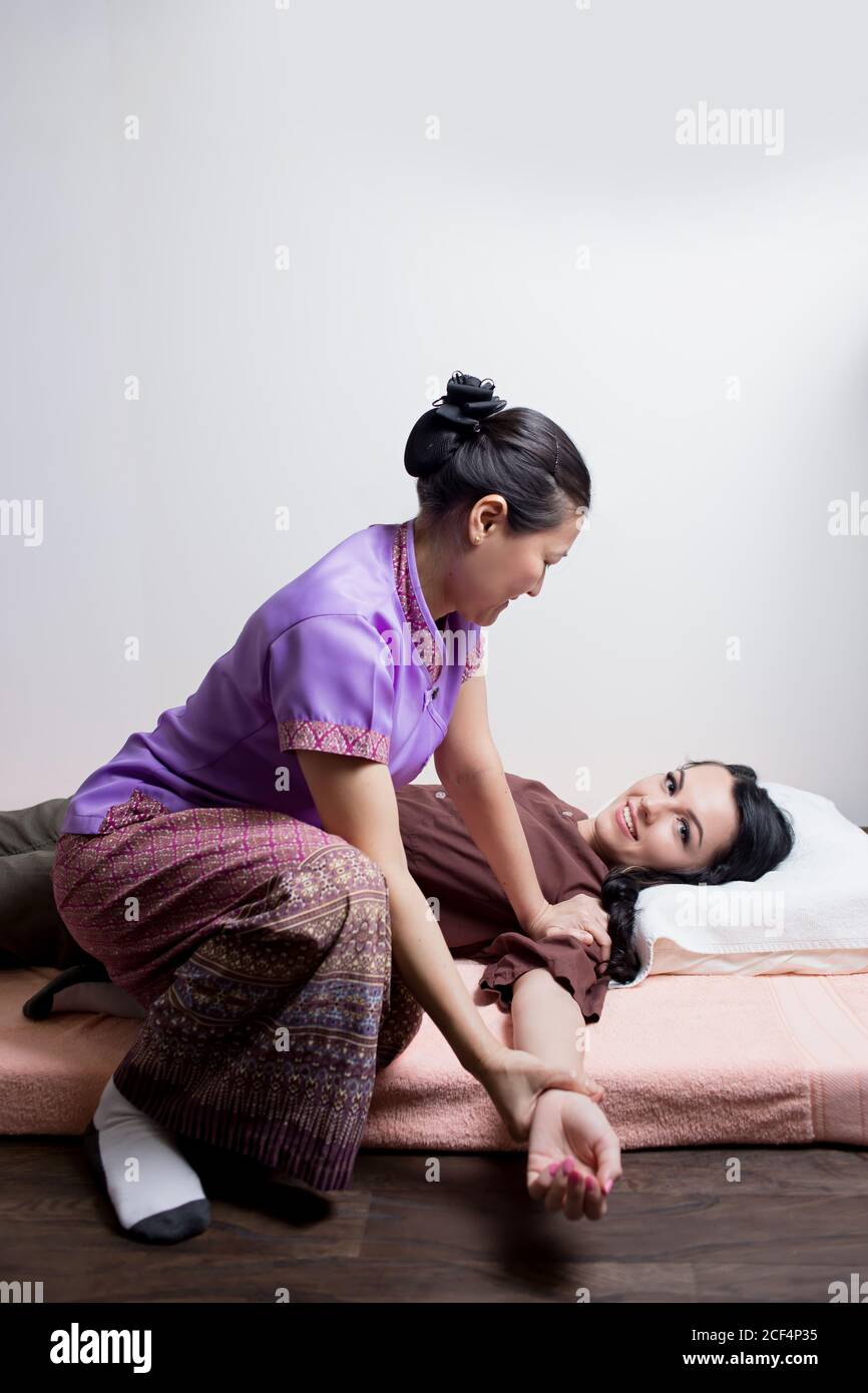 Therapist giving Thai stretching massage to woman Stock Photo - Alamy