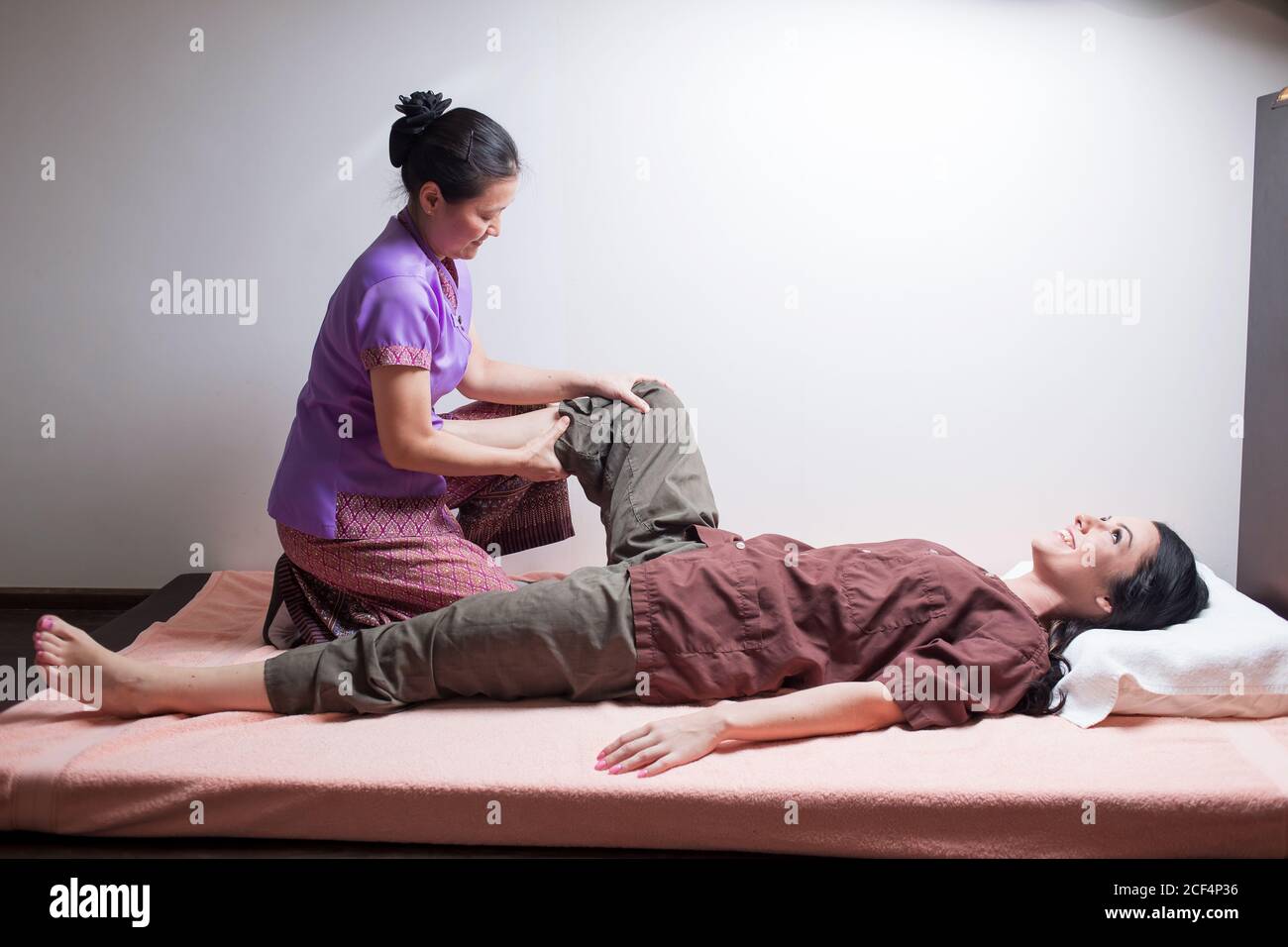 Thai massage leg stretching Stock Photo - Alamy