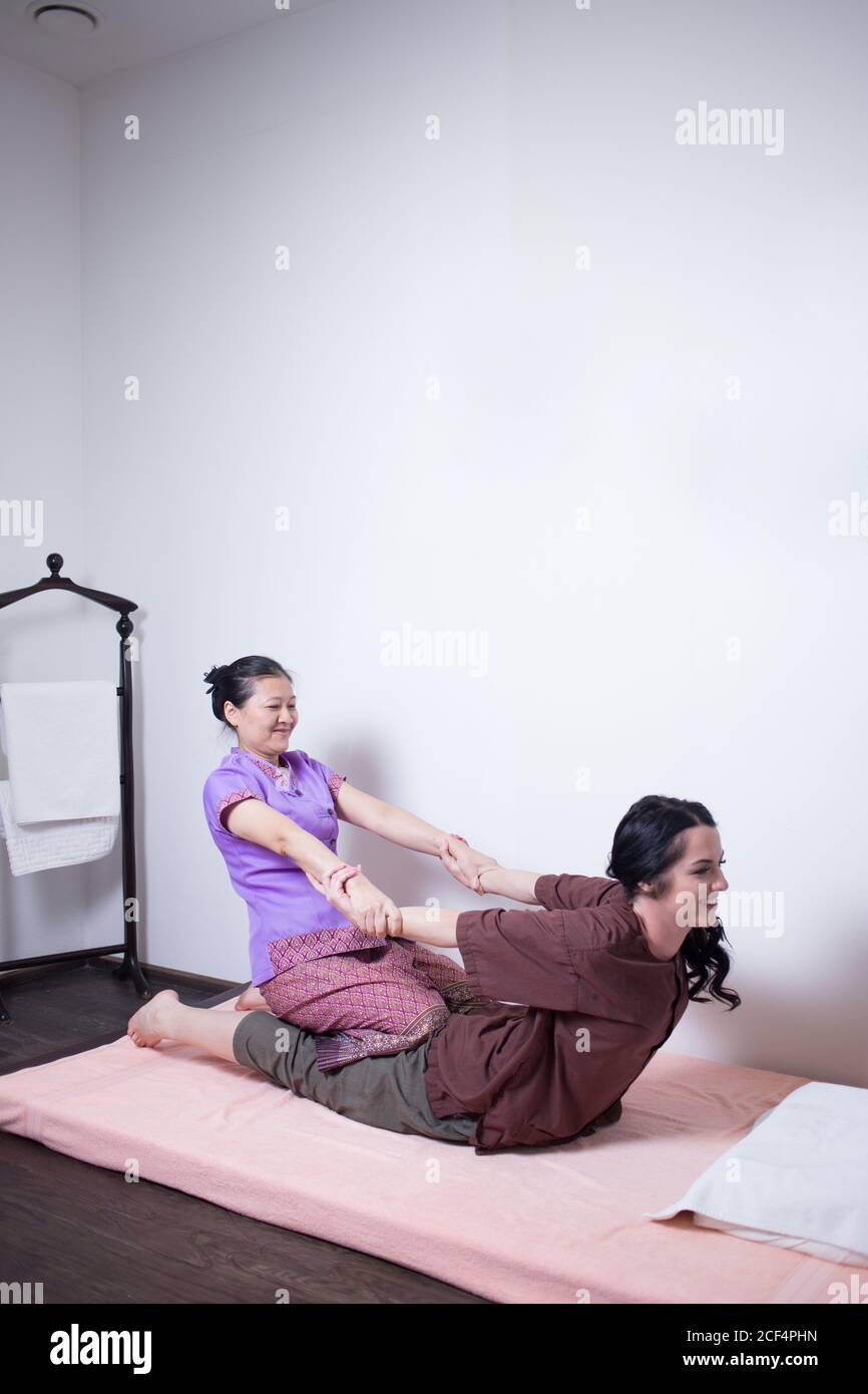 Young Woman Getting Traditional Thai Stretching Massage By Asian