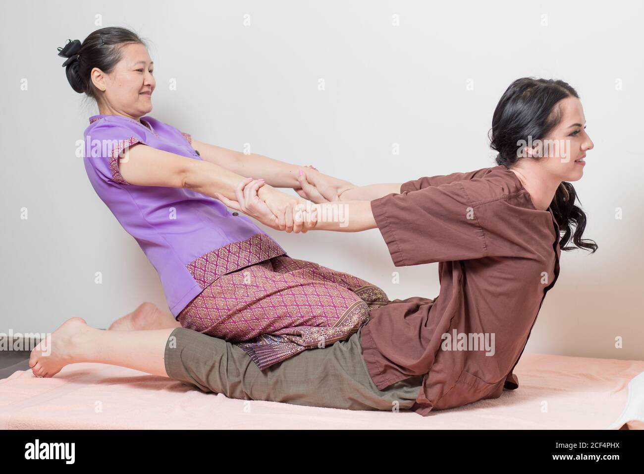 Young Woman Getting Traditional Thai Stretching Massage By Asian