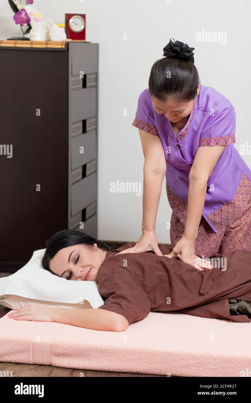 Therapist giving Thai stretching massage to woman Stock Photo - Alamy