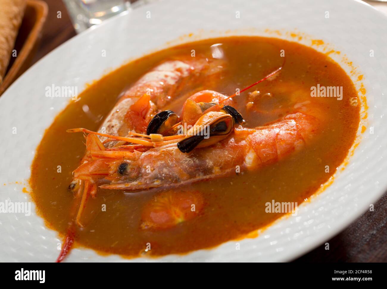 Spicy seafood broth with king prawns and shellfish Stock Photo - Alamy